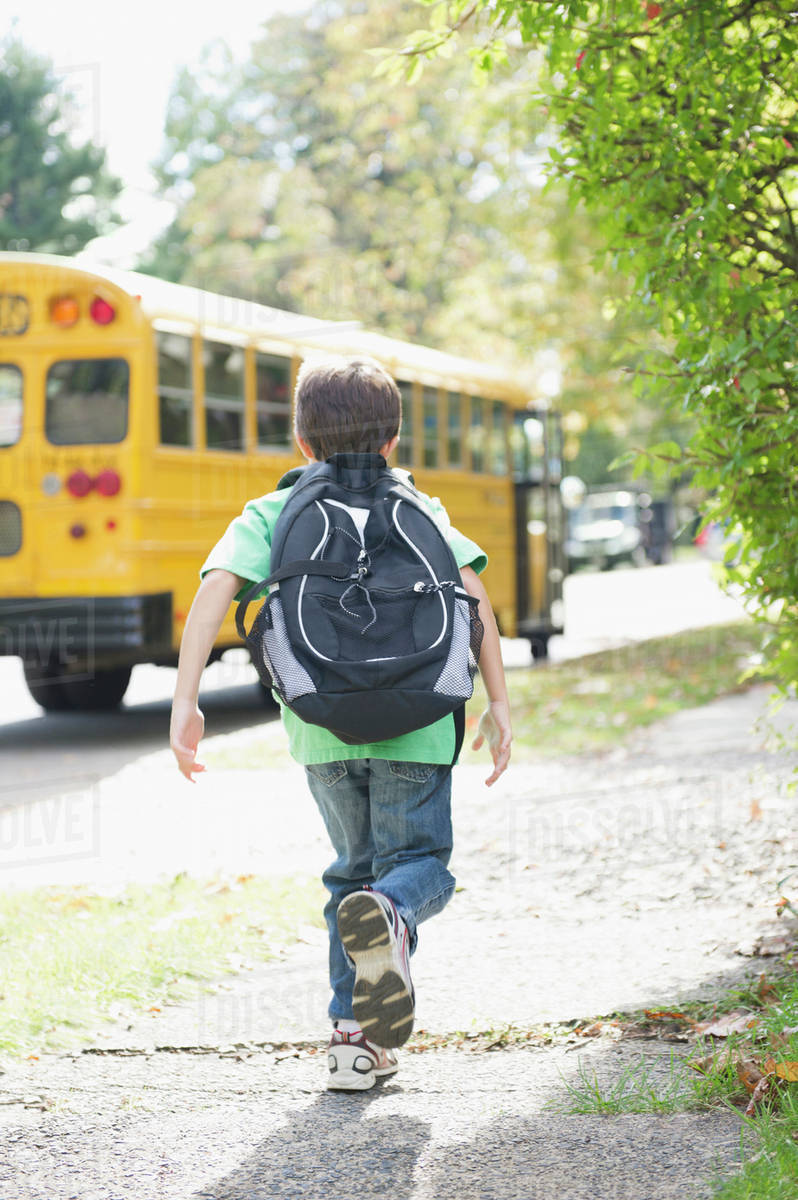 Caucasian boy running after school bus - Royalty-free Stock Photo ...