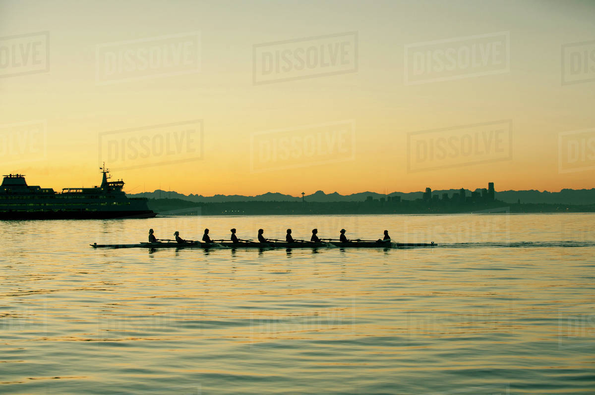 Team rowing boat in bay - Royalty-free Stock Photo | Dissolve