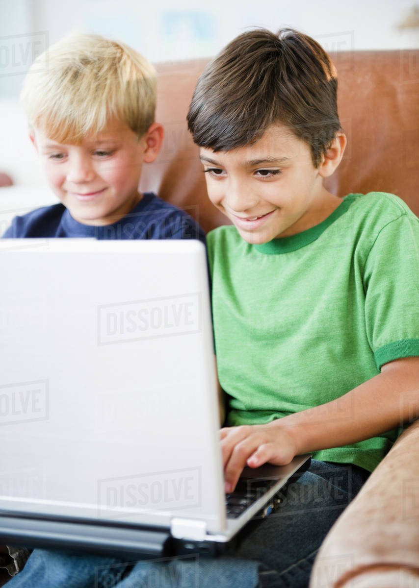 Boys using laptop together - Royalty-free Stock Photo | Dissolve