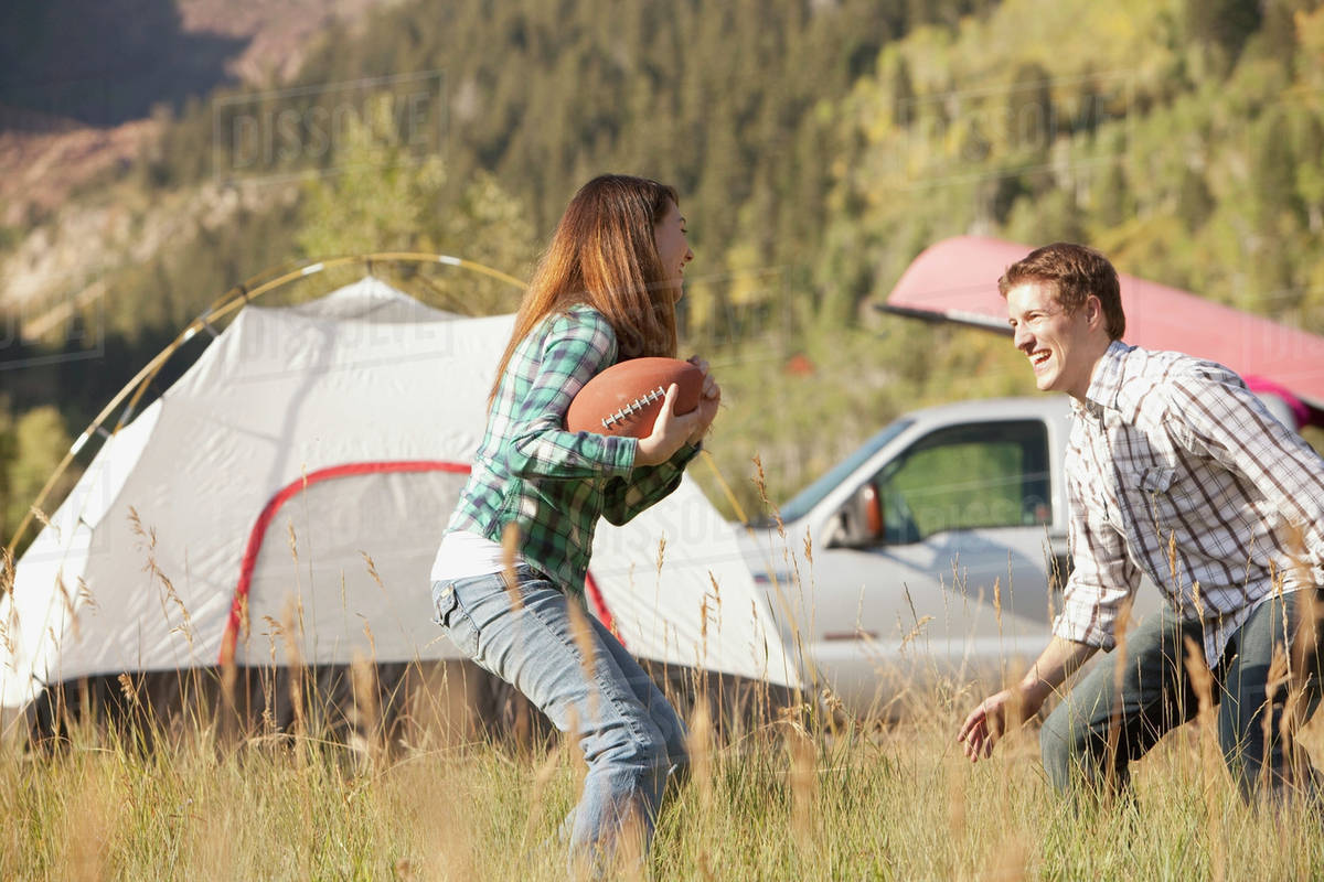 Caucasian couple playing football at campsite - Royalty-free Stock ...