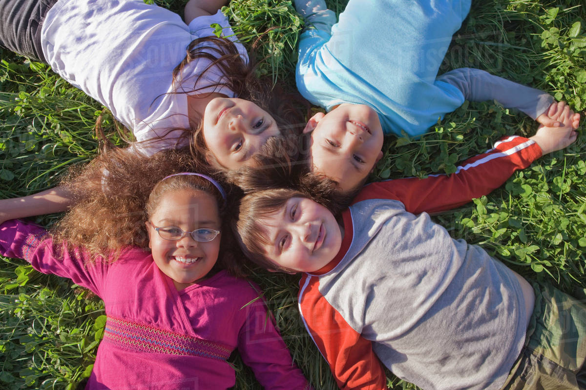 Hispanic children laying in grass together - Royalty-free Stock Photo ...