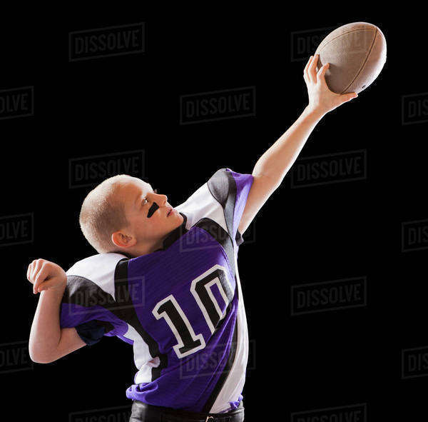Caucasian football player holding up football - Royalty-free Stock ...