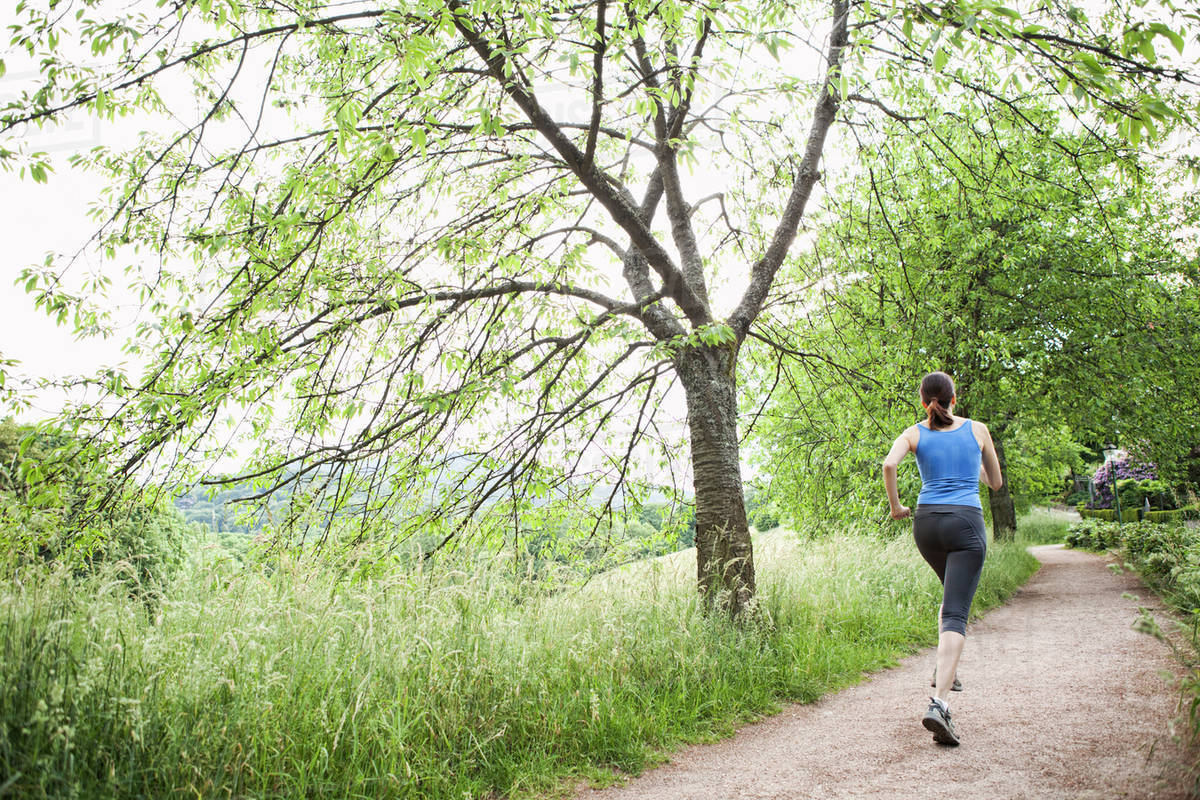 Mixed race woman running on path - Stock Photo - Dissolve