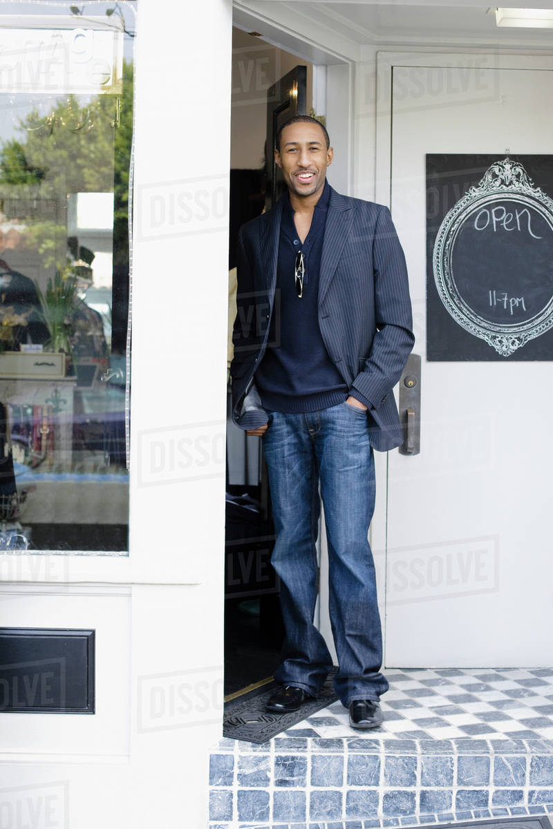 African American man standing in shop doorway - Stock Photo - Dissolve