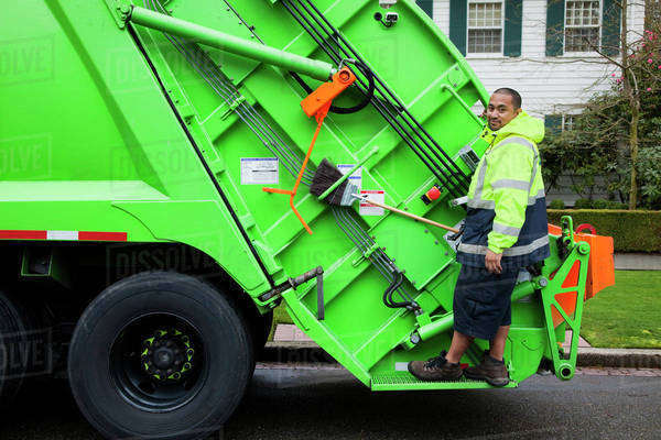 Pacific Islander man riding on garbage truck - Royalty-free Stock Photo ...