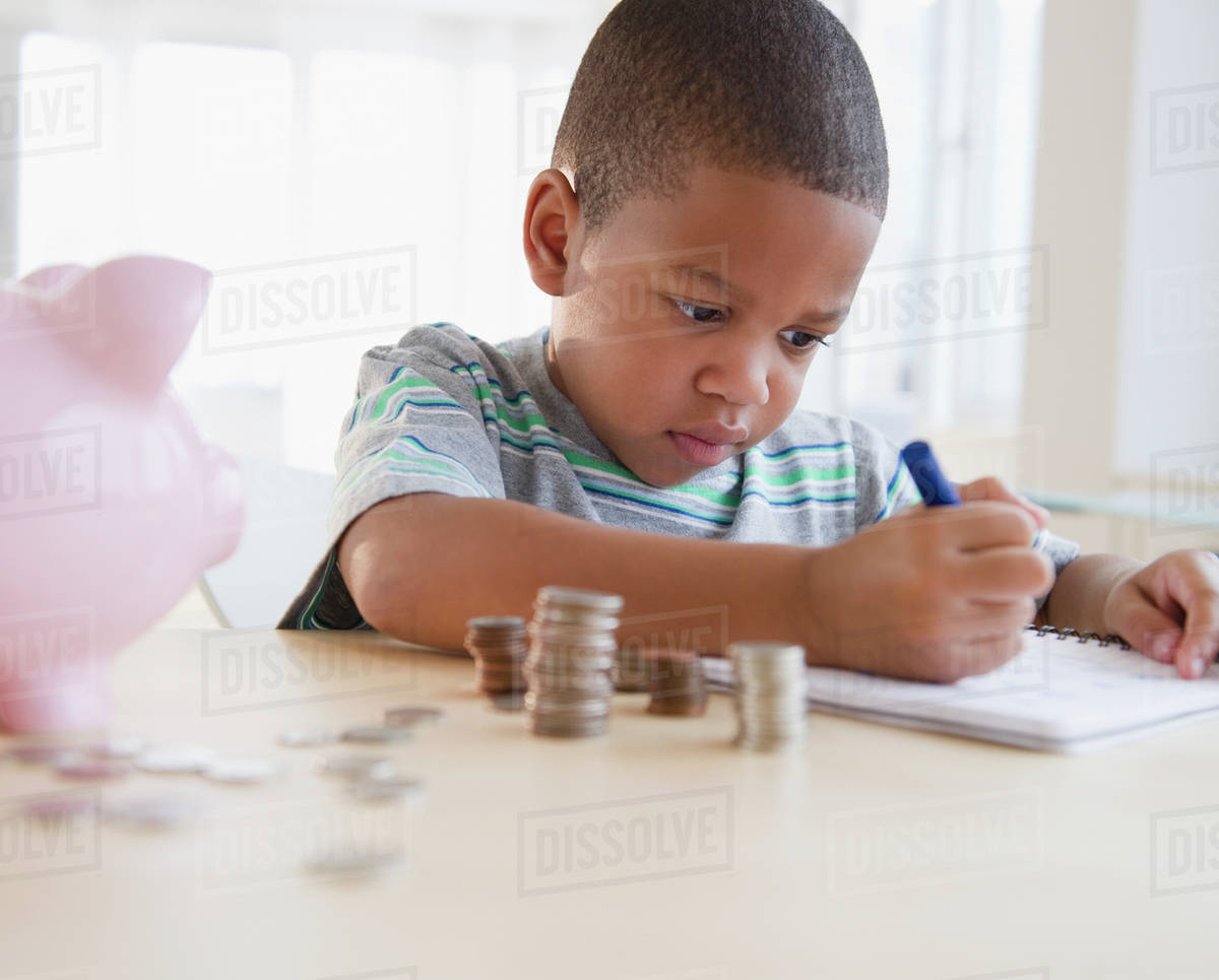 African American boy counting coins - Royalty-free Stock Photo | Dissolve