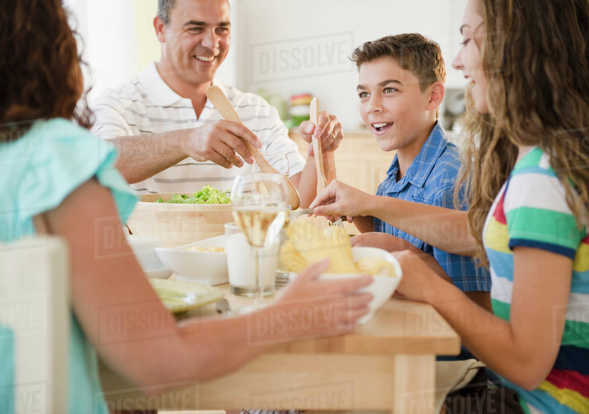 Happy family eating dinner together - Royalty-free Stock Photo | Dissolve