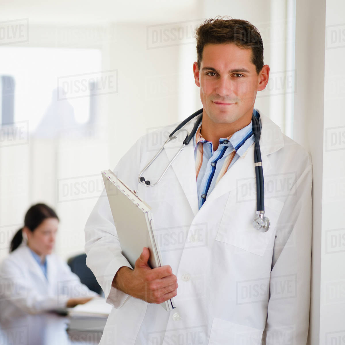 Mixed race doctor holding medical record in doctor's office - Royalty ...
