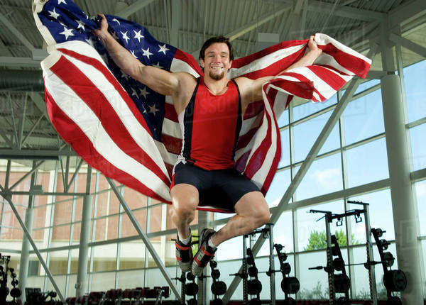 Caucasian athlete jumping with American flag - Stock Photo - Dissolve