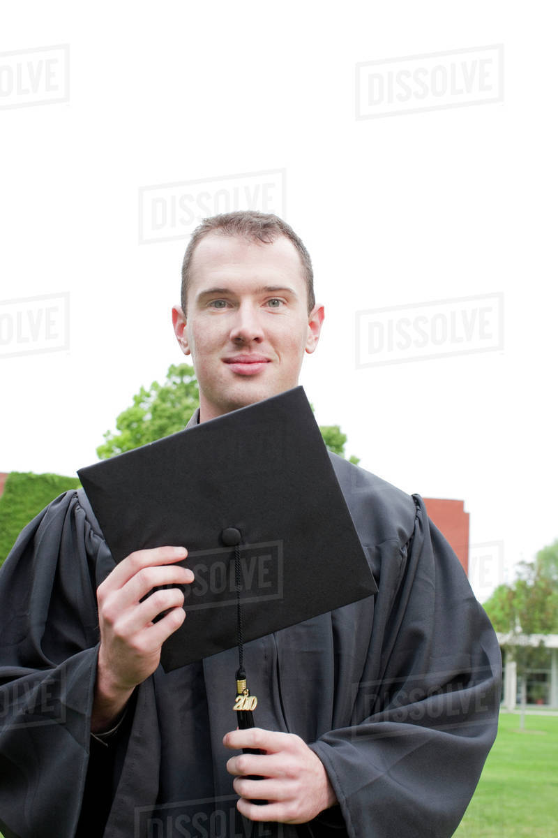 Caucasian graduate holding graduation cap - Royalty-free Stock Photo ...