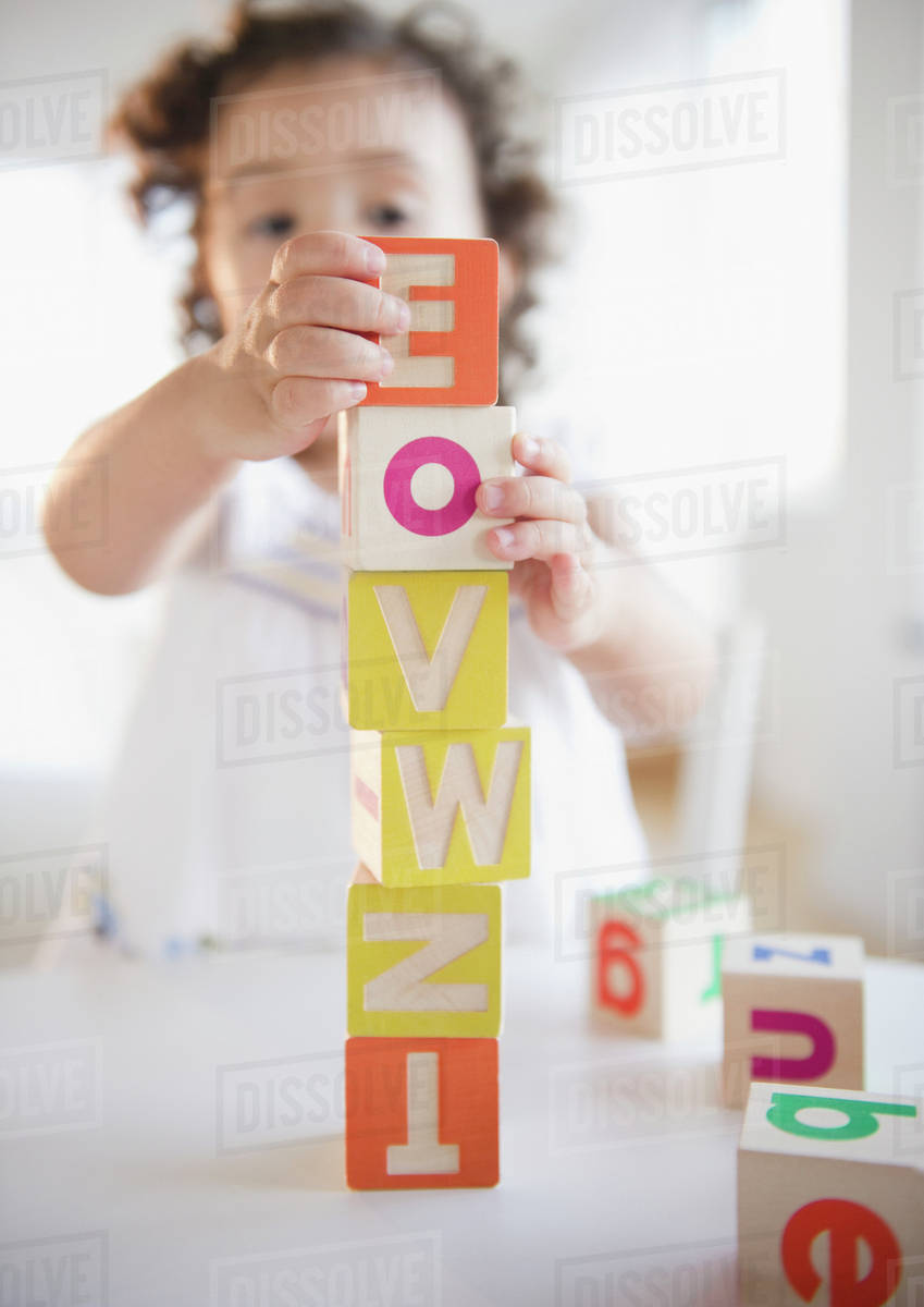 Mixed race girl stacking blocks - Royalty-free Stock Photo | Dissolve