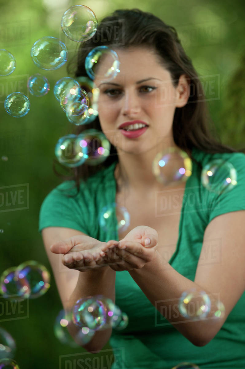 Caucasian woman trying to catch bubbles in her hands - Royalty-free ...