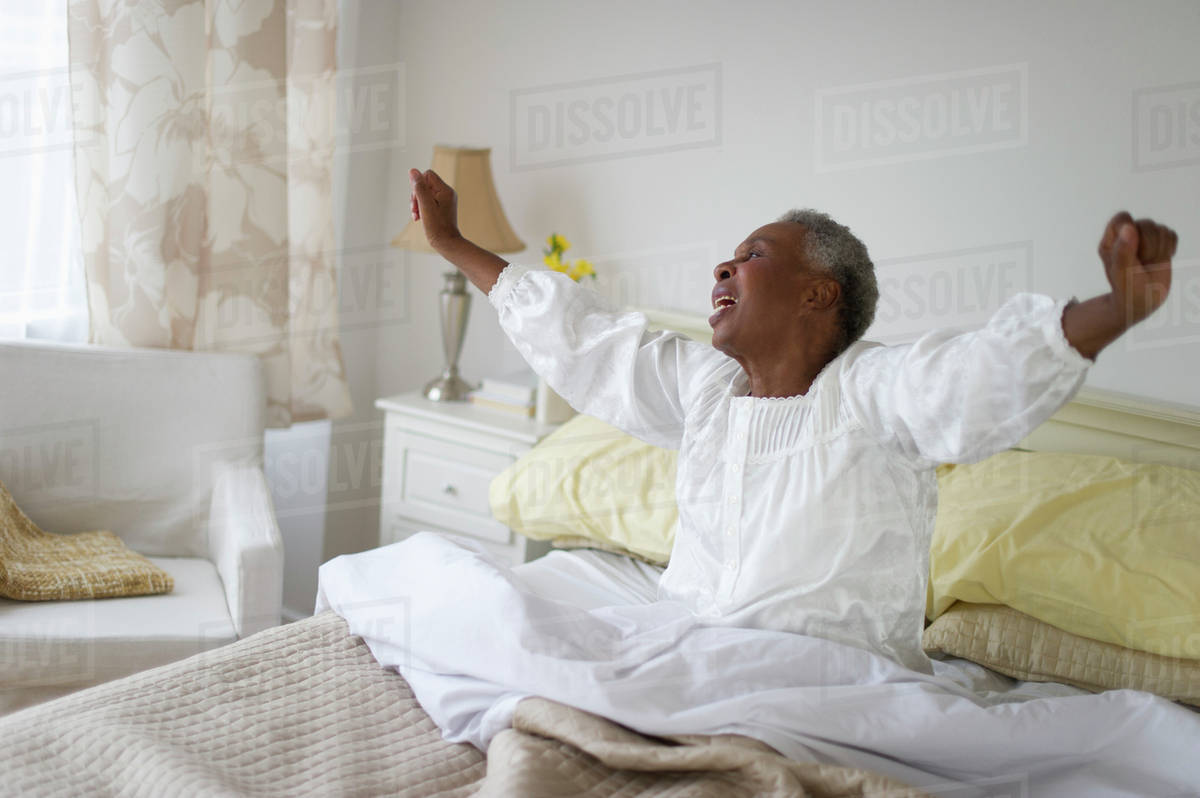 Black woman waking up in bed - Royalty-free Stock Photo | Dissolve
