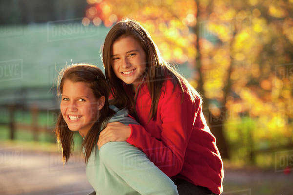Caucasian girl carrying friend on her back - Royalty-free Stock Photo ...