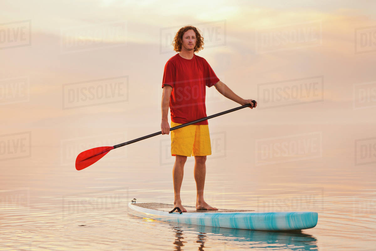 Caucasian man standing on paddle board - Royalty-free Stock Photo ...