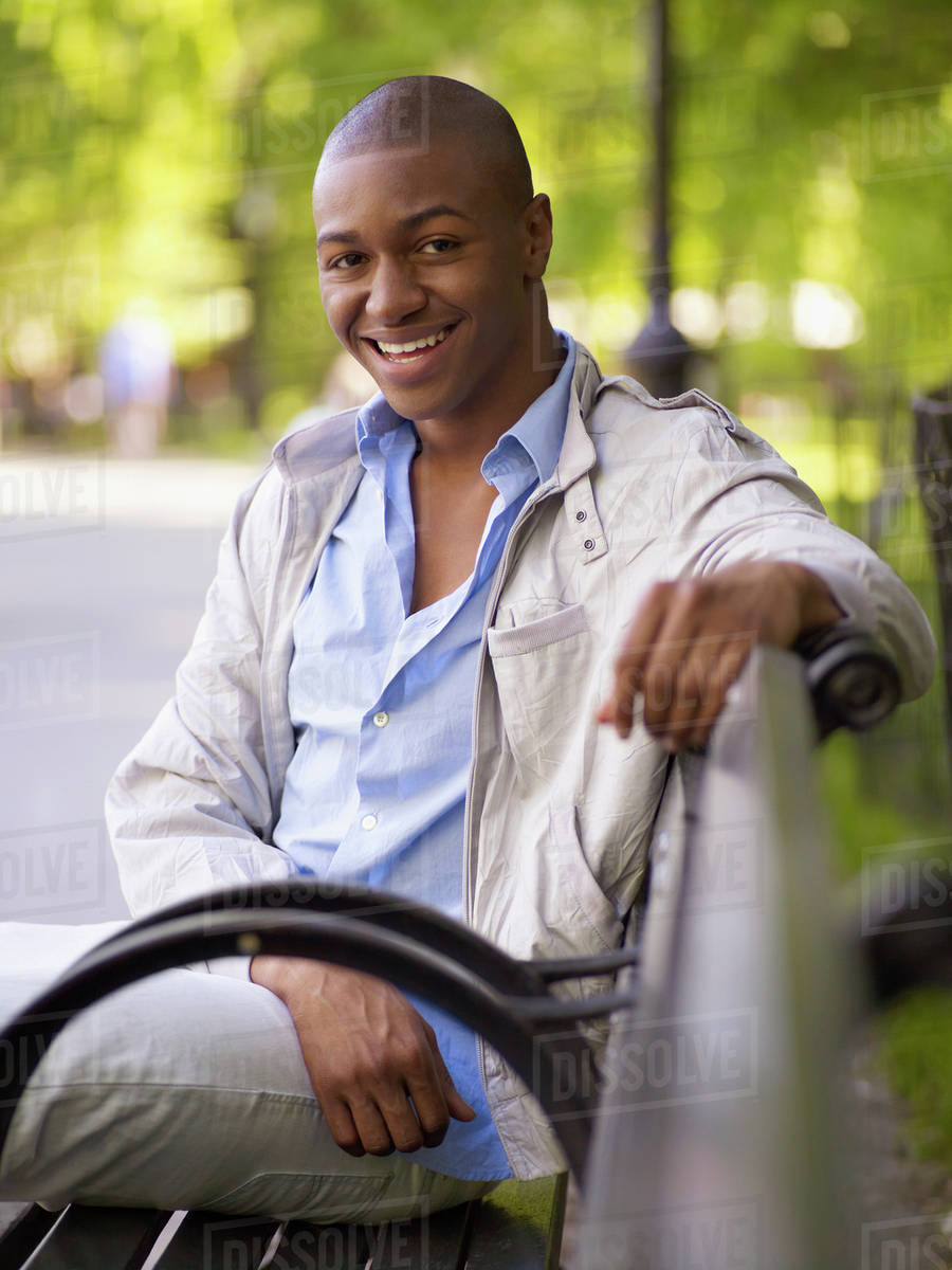 African man smiling on bench - Royalty-free Stock Photo | Dissolve