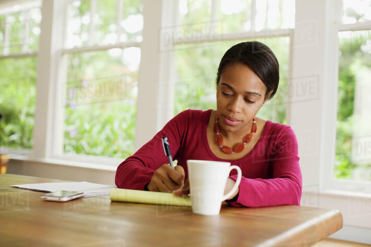 African woman working at table - Royalty-free Stock Photo | Dissolve