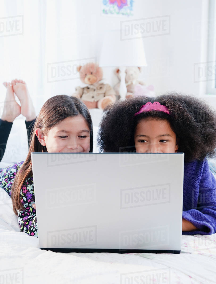 Girls using laptop together - Royalty-free Stock Photo | Dissolve