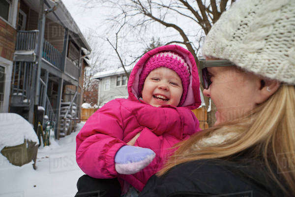 Mother holding grinning girl in coat - Royalty-free Stock Photo | Dissolve