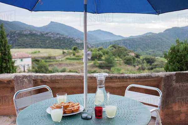 Food and drinks on balcony table over rural landscape - Stock Photo ...