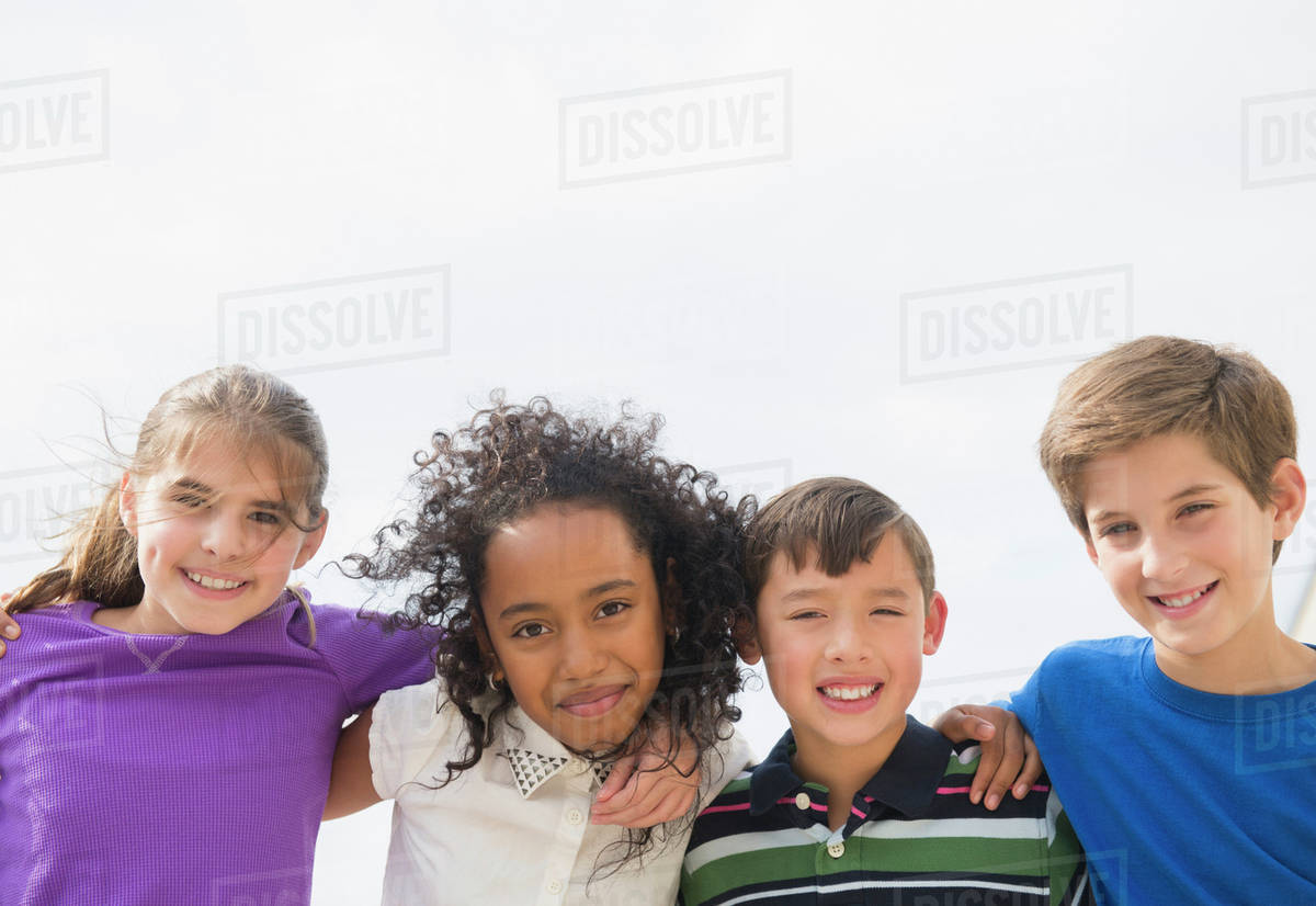Smiling children hugging outdoors - Stock Photo - Dissolve