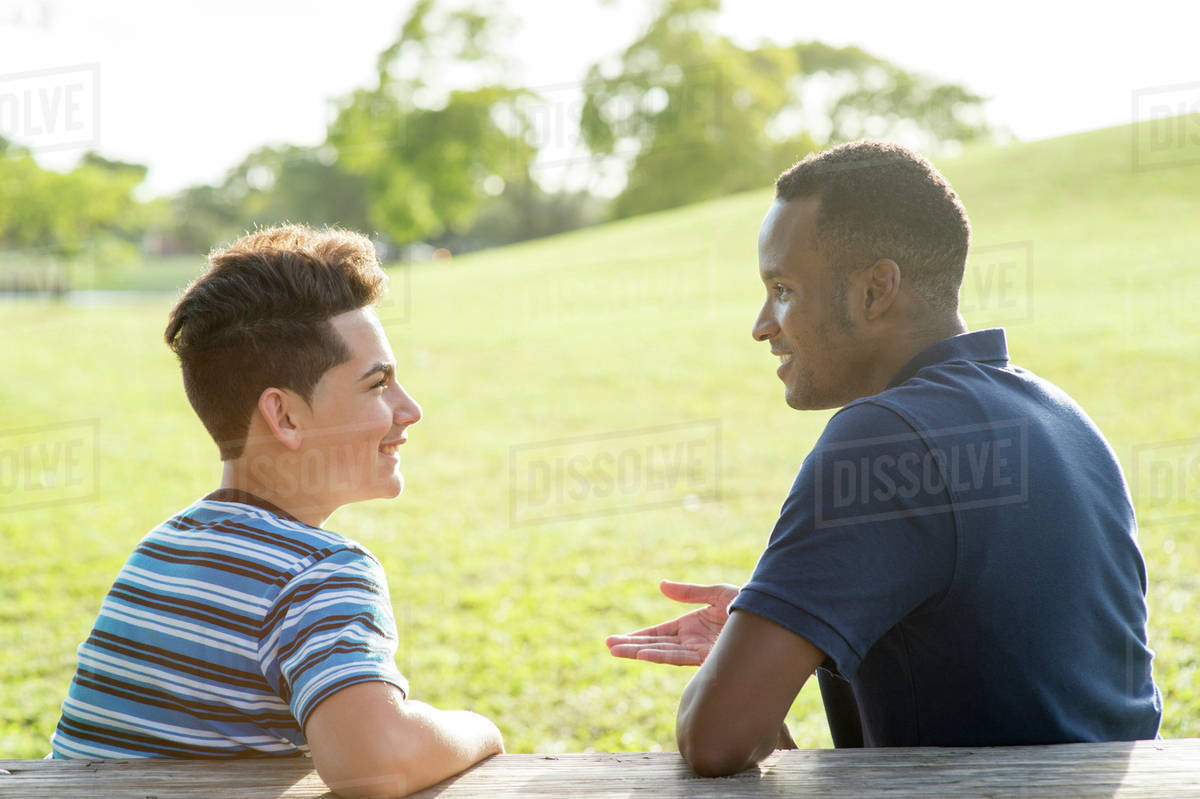 Father and son talking at table in park - Royalty-free Stock Photo ...