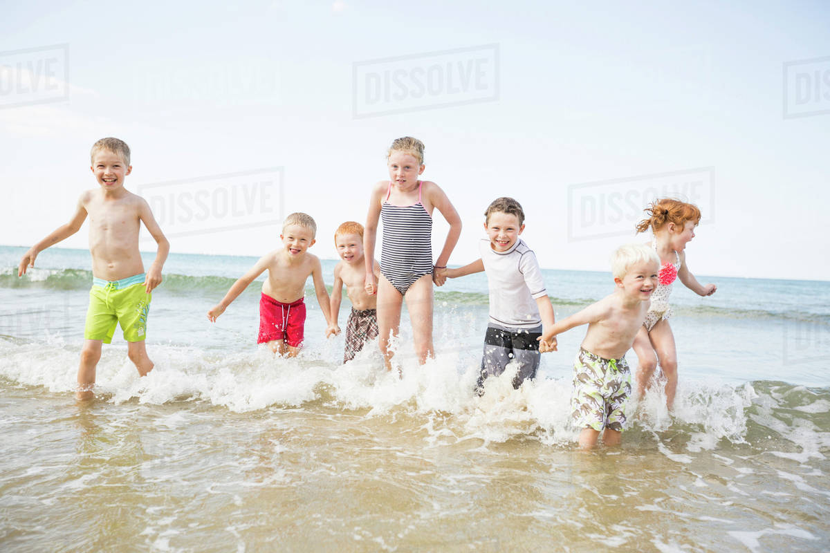 Caucasian children playing in waves on beach - Royalty-free Stock Photo ...
