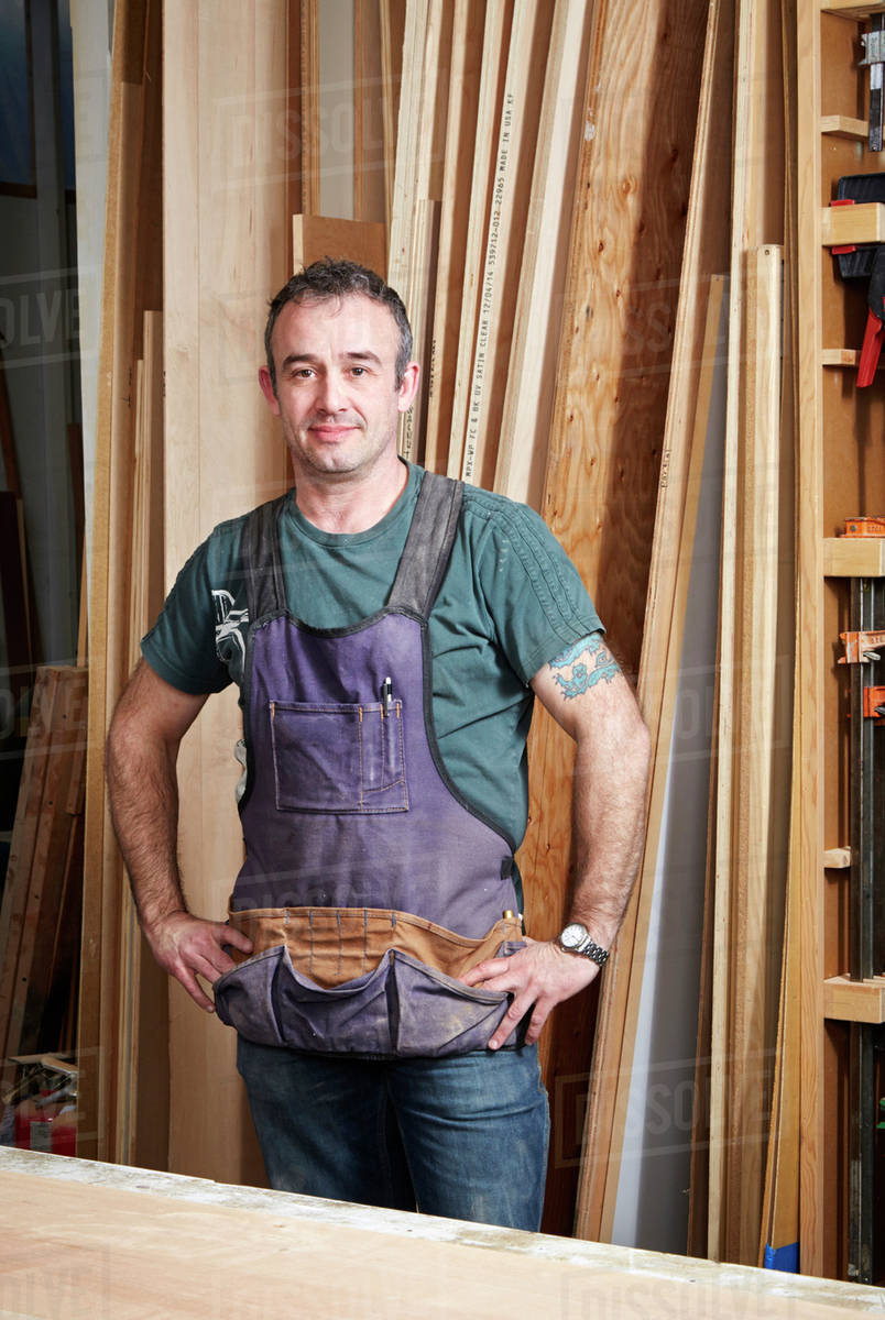 Carpenter smiling in workshop - Royalty-free Stock Photo | Dissolve