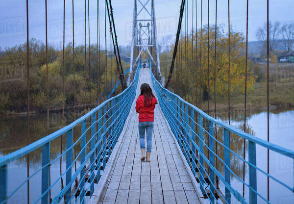 Caucasian girl walking on bridge - Royalty-free Stock Photo | Dissolve