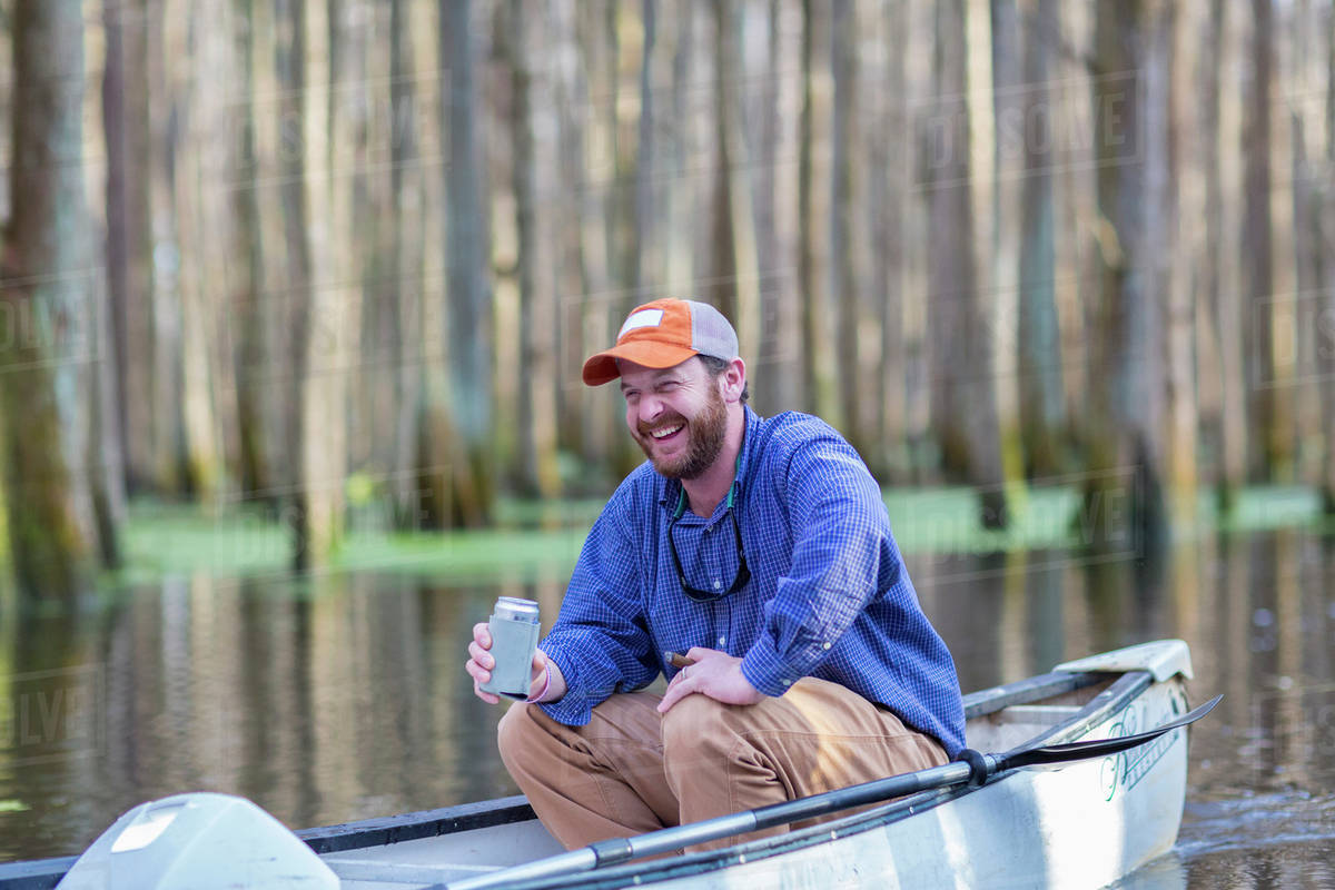 Caucasian man drinking beer in canoe on river - Royalty-free Stock ...