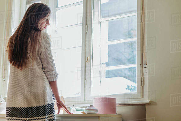 Caucasian woman standing at window - Stock Photo - Dissolve