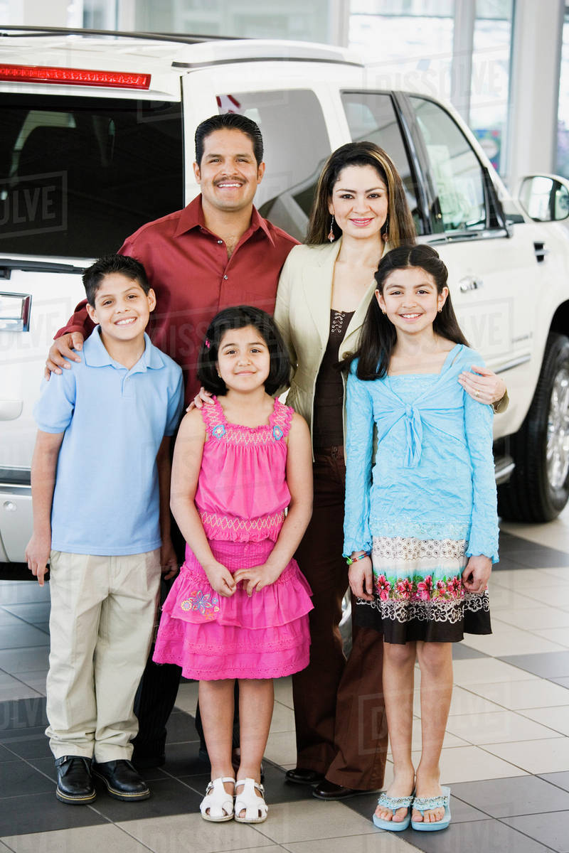 Hispanic family at car dealership - Stock Photo - Dissolve