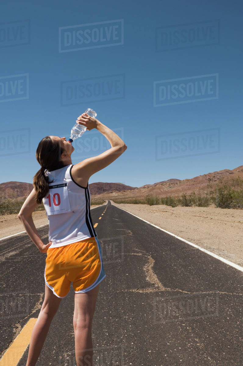 Mixed Race female runner drinking water - Royalty-free Stock Photo ...