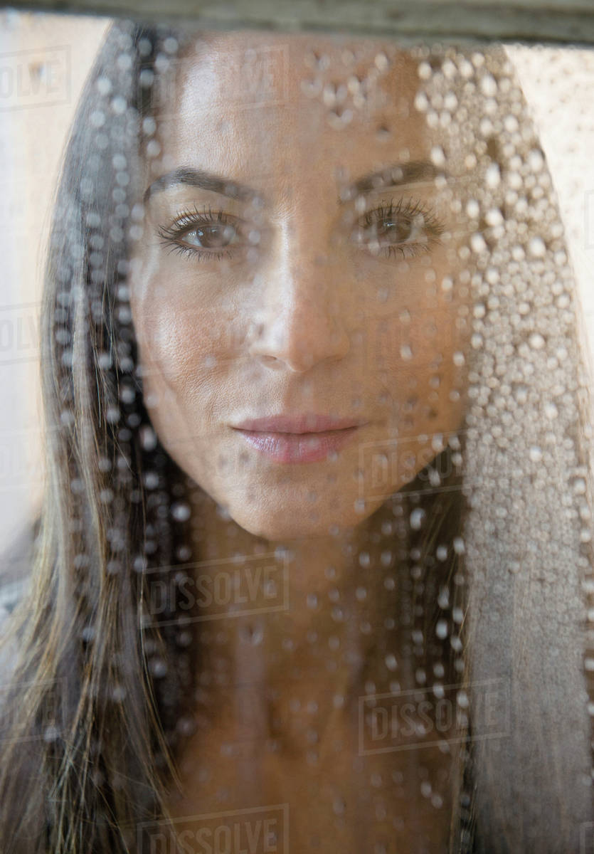 Caucasian woman peering through wet window - Royalty-free Stock Photo ...
