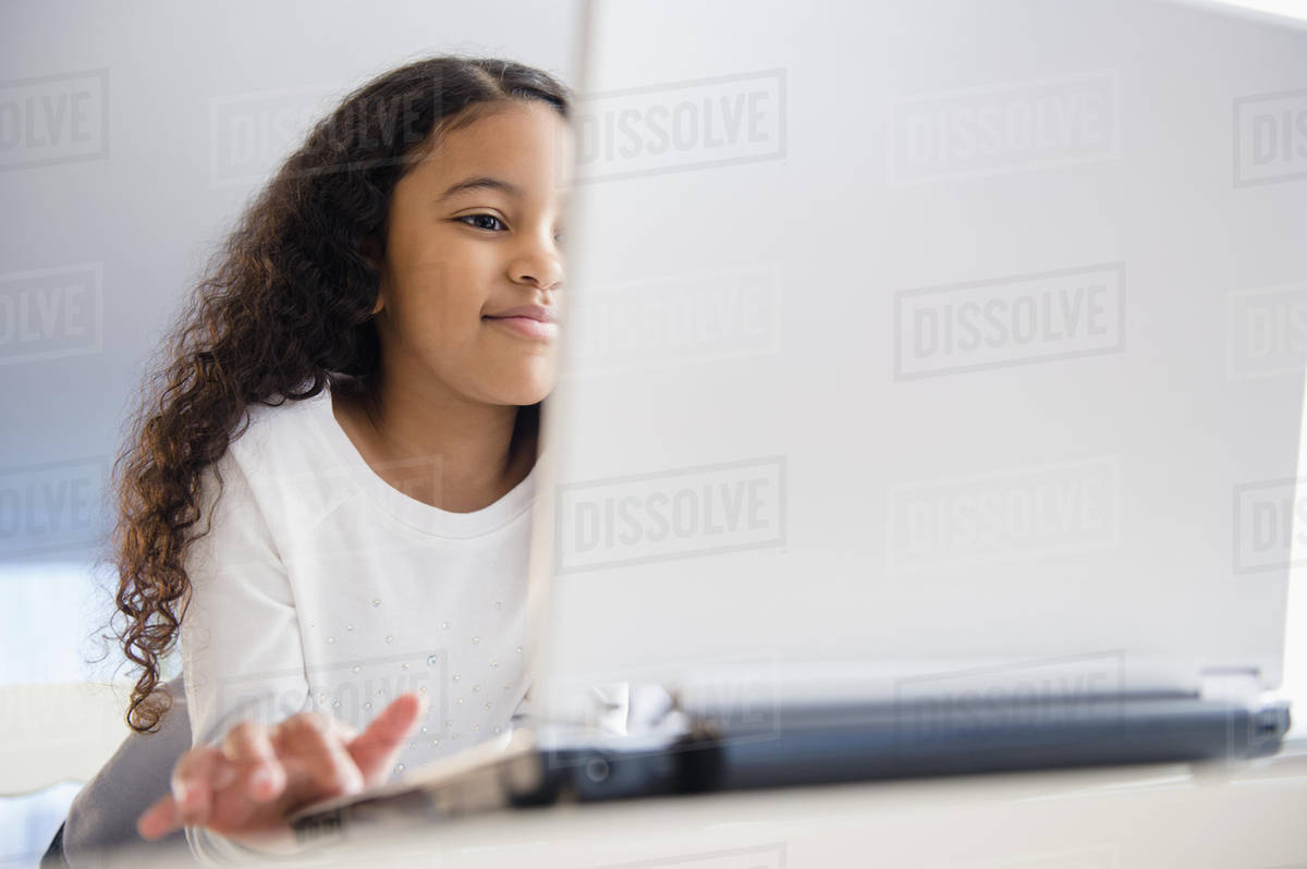 Close up of mixed race girl using laptop - Stock Photo - Dissolve
