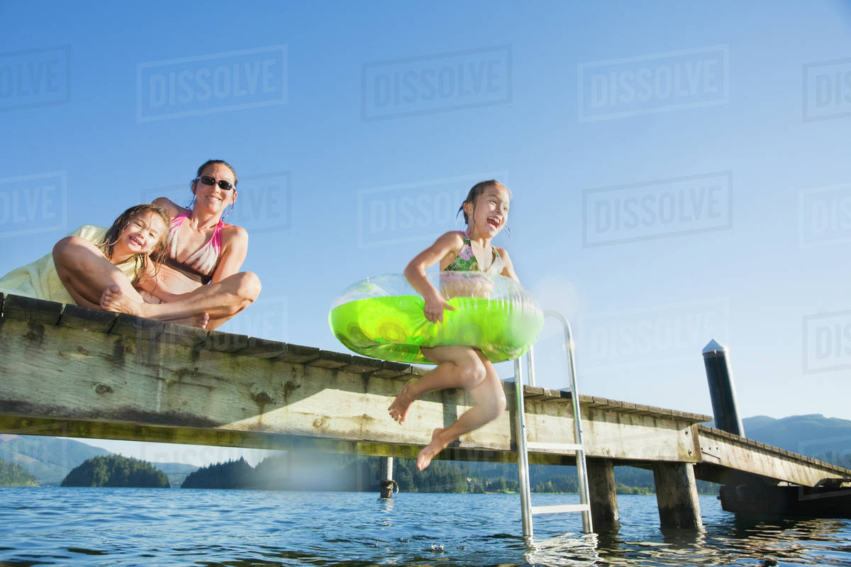 Asian girl jumping in lake - Royalty-free Stock Photo | Dissolve