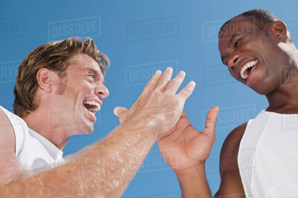 Multi-ethnic men high-fiving - Royalty-free Stock Photo | Dissolve