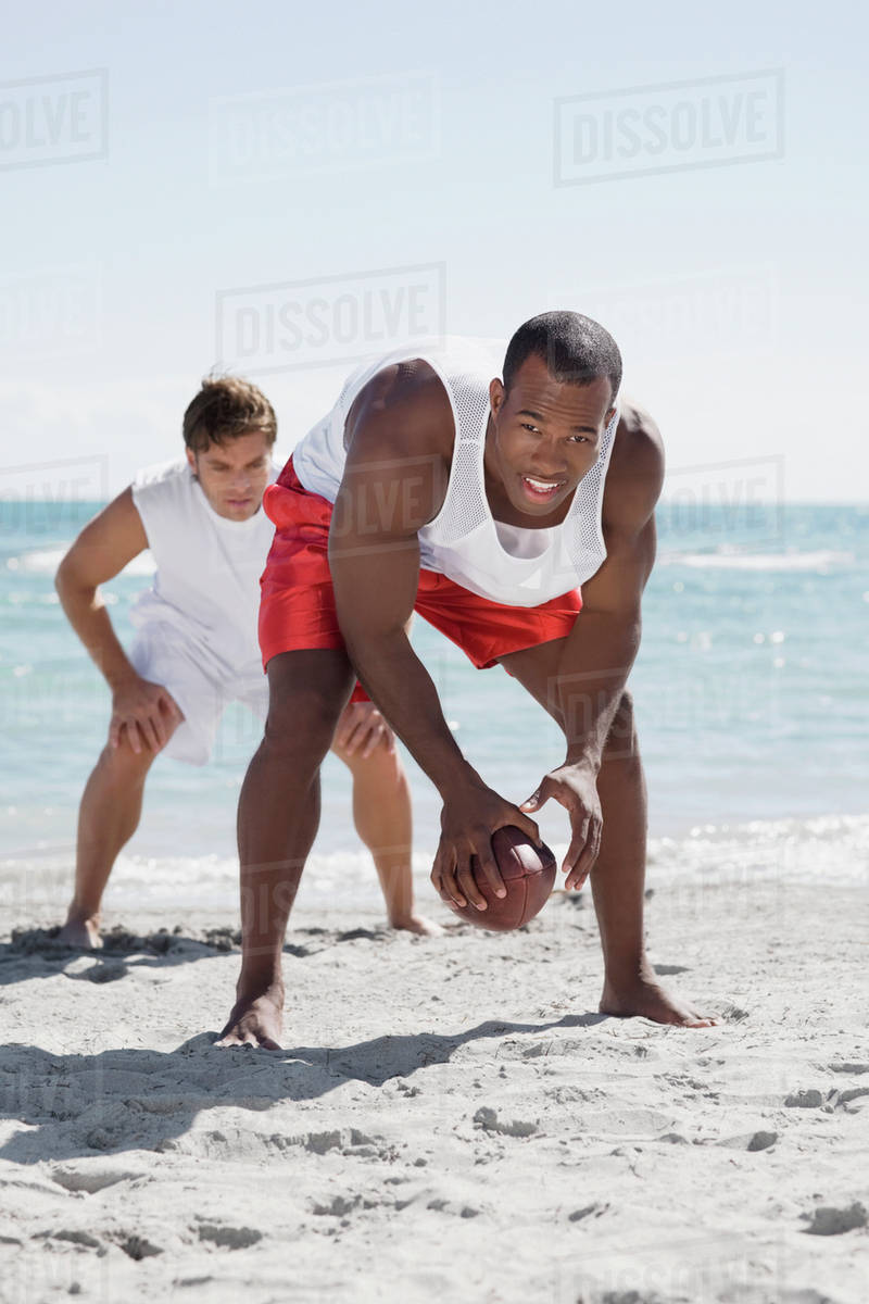 Multi-ethnic men playing football - Royalty-free Stock Photo | Dissolve