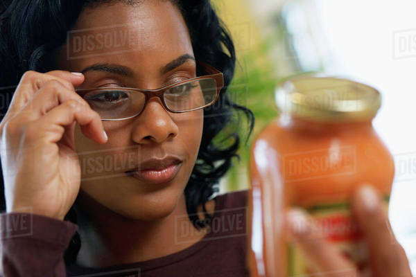 African woman reading sauce ingredients - Royalty-free Stock Photo ...