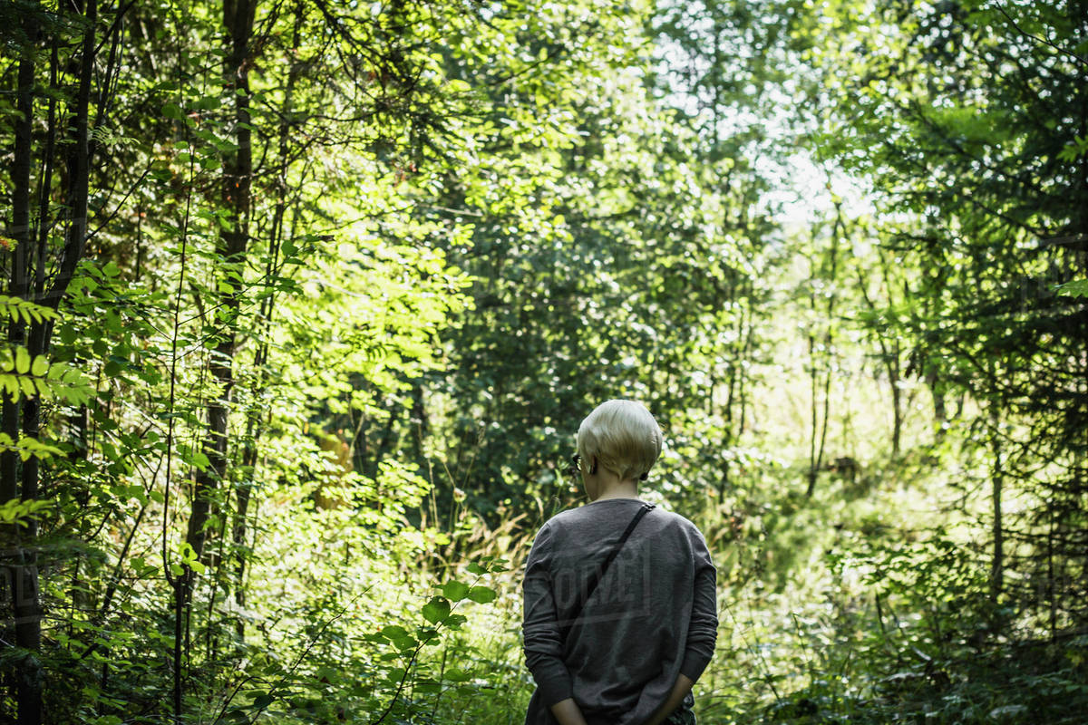 Caucasian woman standing in forest - Royalty-free Stock Photo | Dissolve