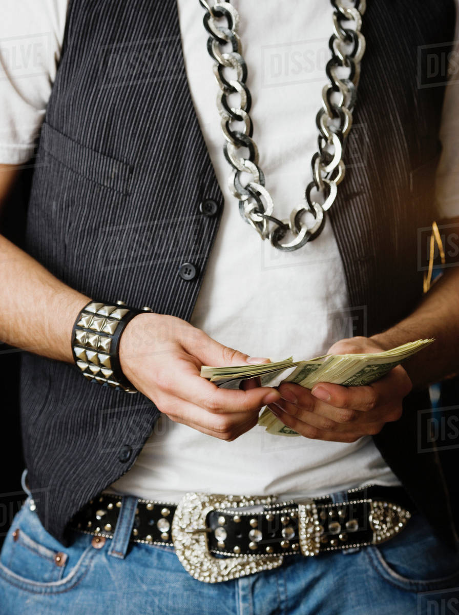 Hispanic man counting stack of money - Royalty-free Stock Photo | Dissolve