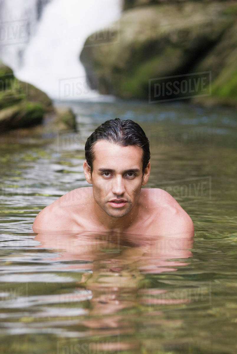 Hispanic man swimming in stream - Royalty-free Stock Photo | Dissolve