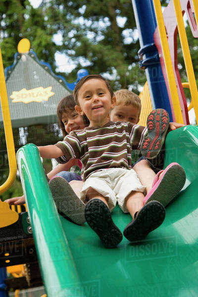 Children sliding in playground - Royalty-free Stock Photo | Dissolve
