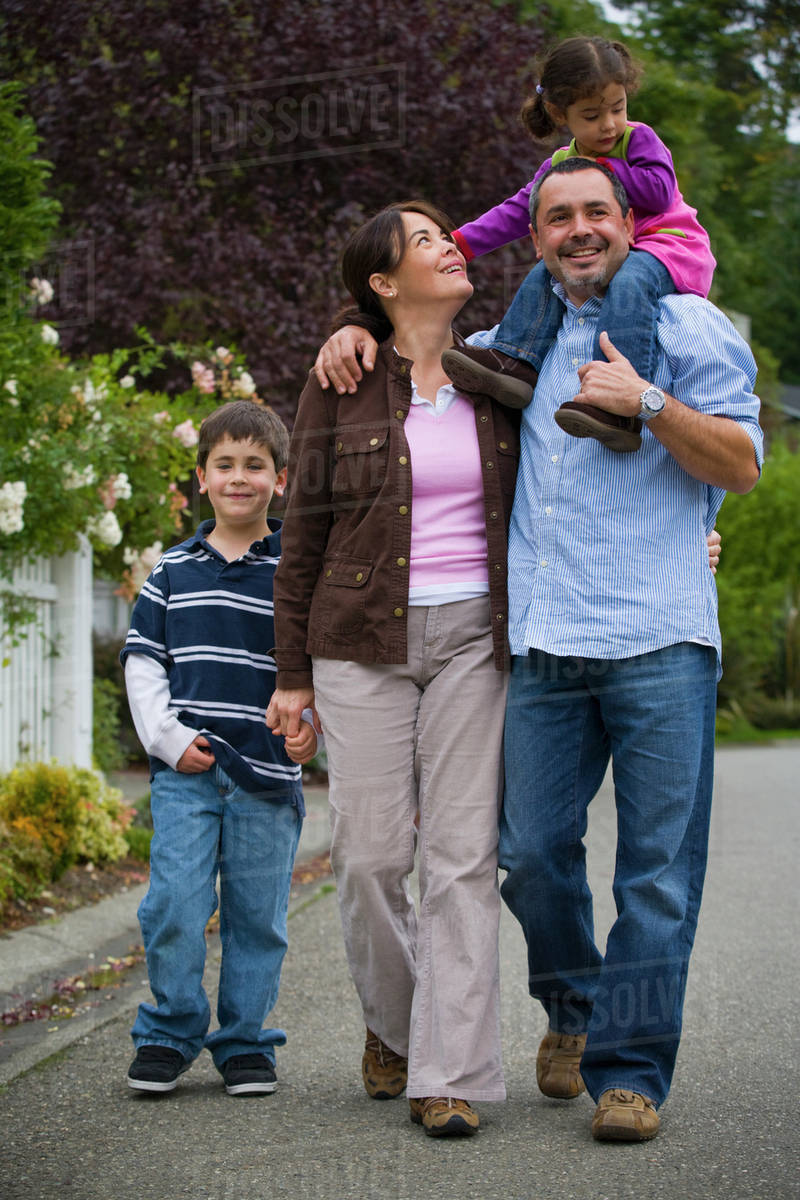 Family walking on residential street - Royalty-free Stock Photo | Dissolve