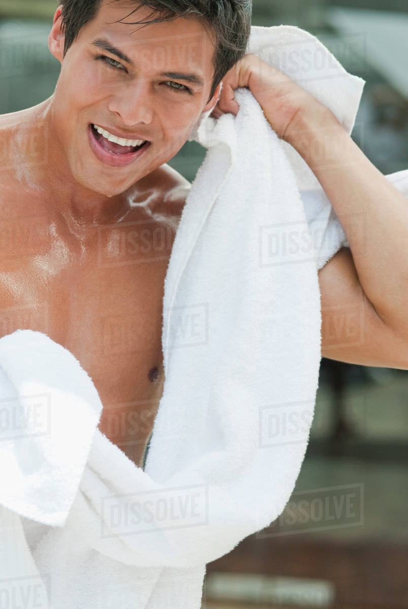 Wet Hispanic man drying off - Stock Photo - Dissolve