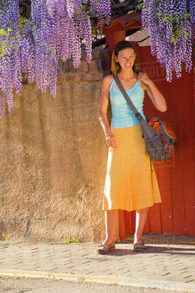 Caucasian woman standing underneath flowers - Stock Photo - Dissolve