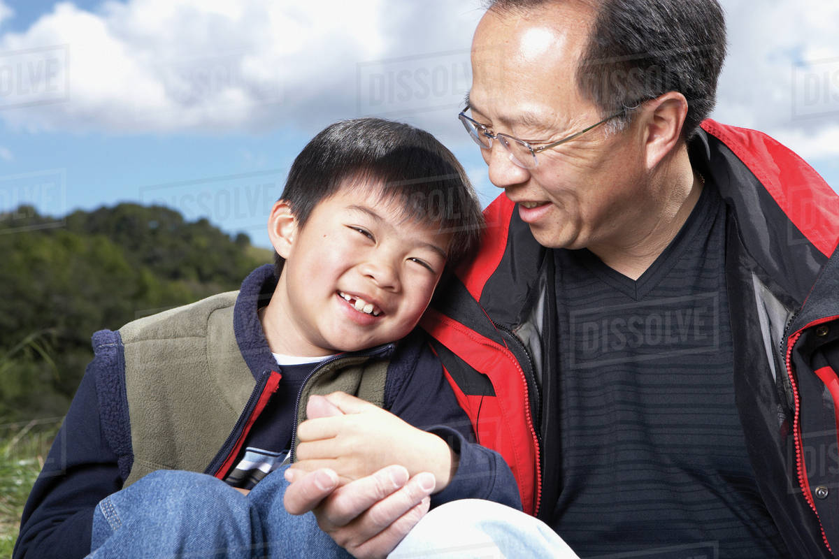 Asian father and son smiling outdoors - Royalty-free Stock Photo | Dissolve