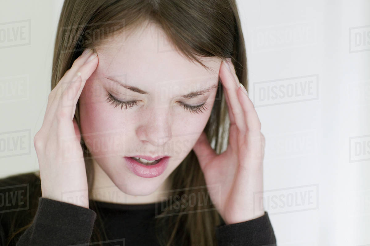 Studio shot of young woman rubbing temples - Royalty-free Stock Photo ...