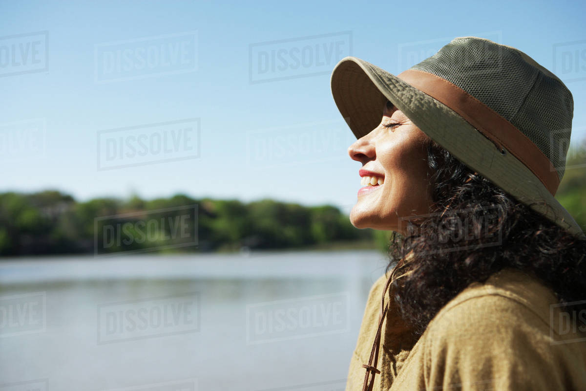 Woman smiling with sun on her face - Royalty-free Stock Photo | Dissolve