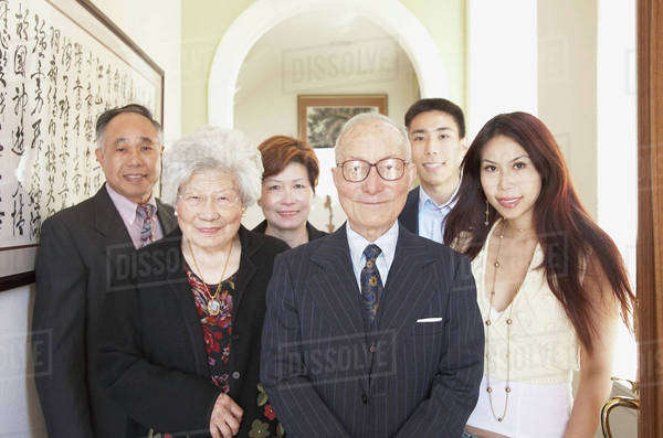 Multi-generational Asian family smiling indoors - Stock Photo - Dissolve